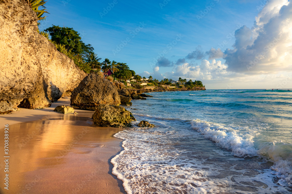 Scenic view of the golden lit tropical shore with oceanfront houses in ...