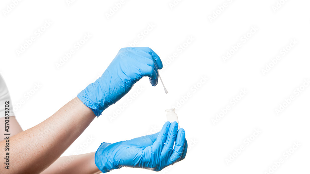 hands in blue sterile gloves to give cotton swab to glass bottle for ...