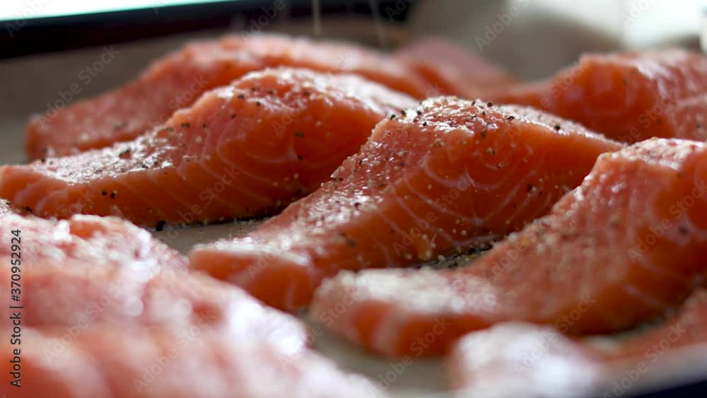 seafood preparation - sprinkle pepper seasoning on salmon fish fillet ...