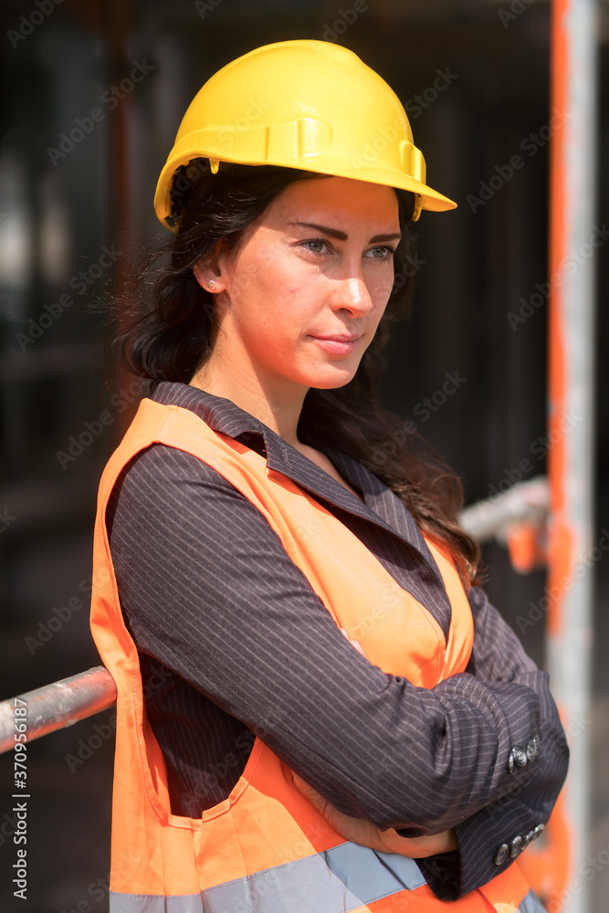 Portrait of a beautiful female factory worker wearing a protective ...