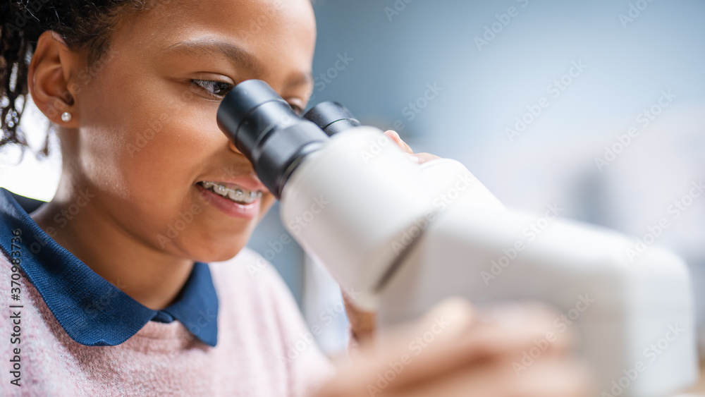 Portrait of Smart Little Schoolgirl Looking Under the Microscope. In ...