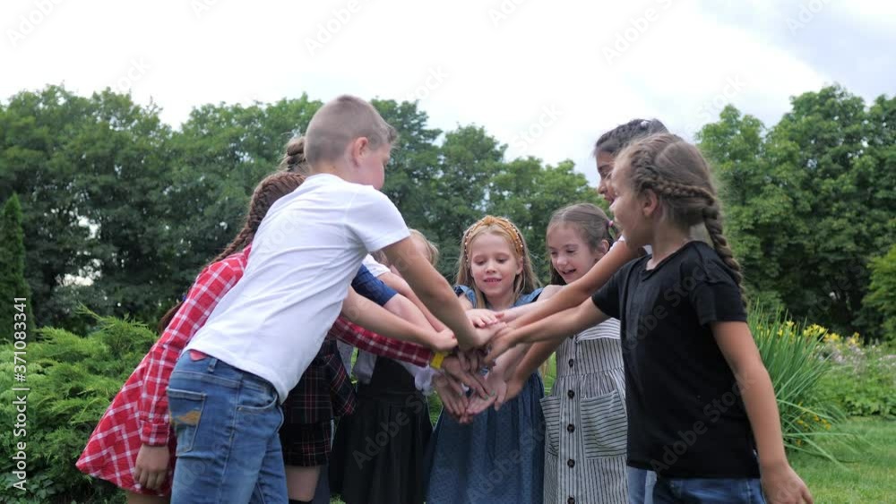 Kids team building. A group of happy children holding hands together ...