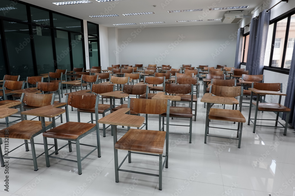 Empty school classroom with many wooden chairs. Wooden chairs in ...