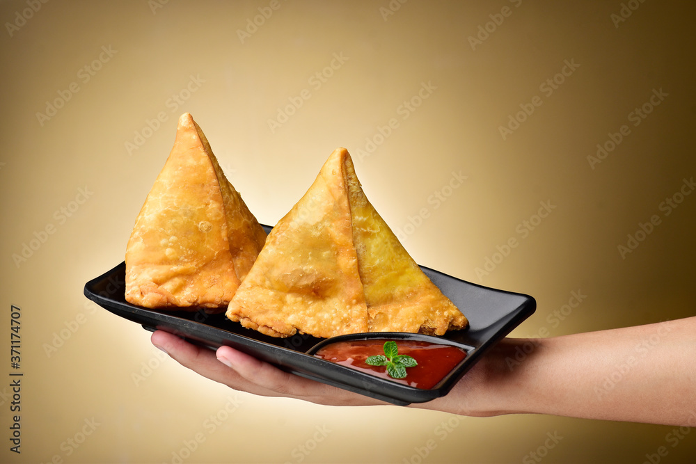 samosa with tomato in hand, indian spicy breakfast aloo samosa Stock ...