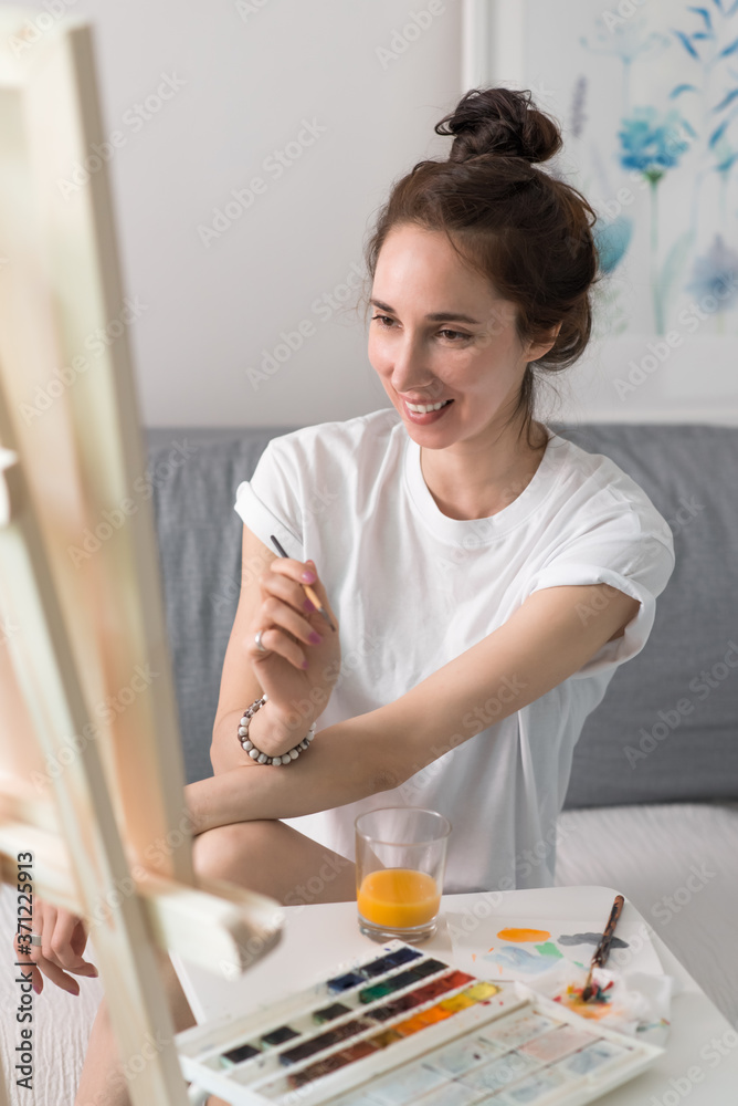Happy and beautiful woman artist, smiling and laughing, at home on the ...