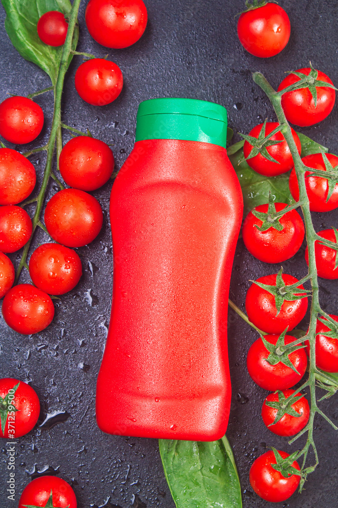 Foto de a bottle, a tube of red ketchup with a green cap and two ripe ...
