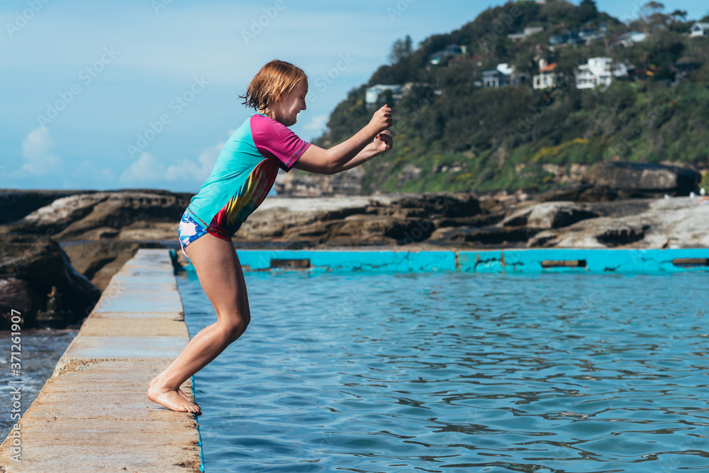 little girl jumping into an ocean pool Stock Photo | Adobe Stock