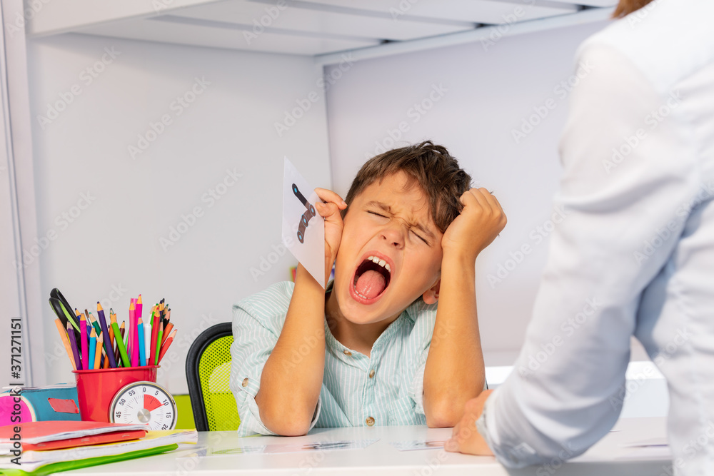 Fotografia do Stock: Autistic child tear hairs and scream expressing ...