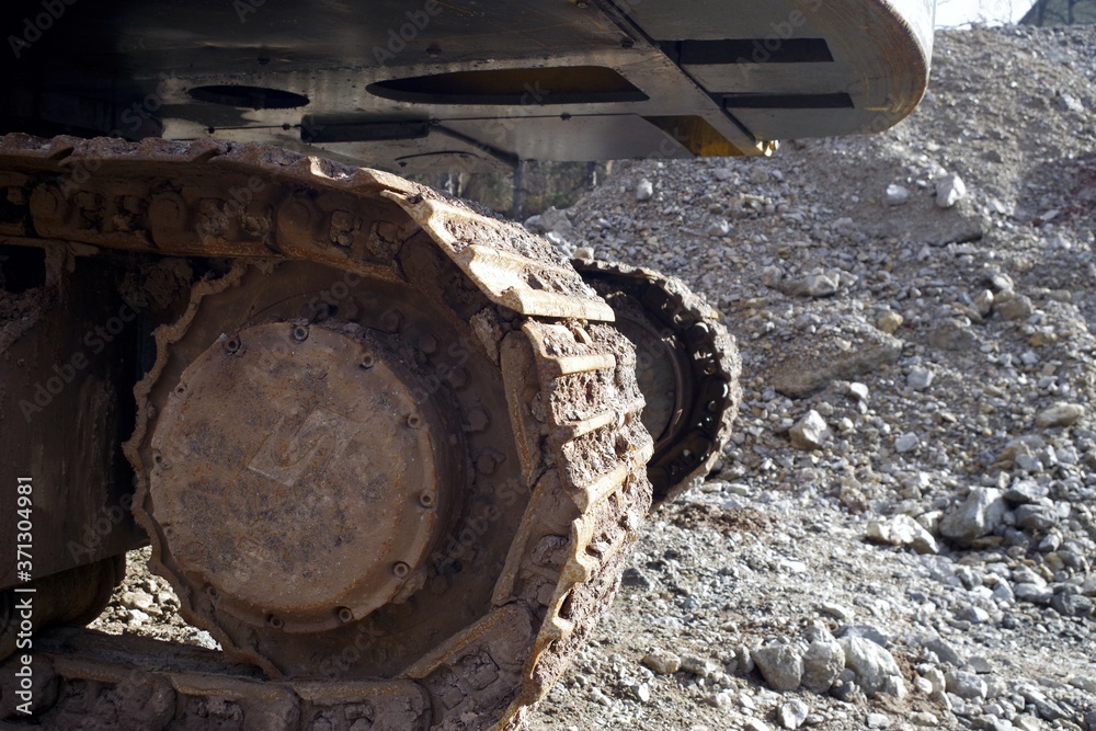 Caterpillars wheel on backhoe. Close-up of metal tracks of a crawler ...