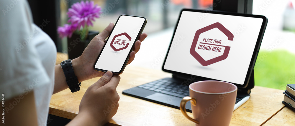 Female college student using mock up smartphone while doing homework ...