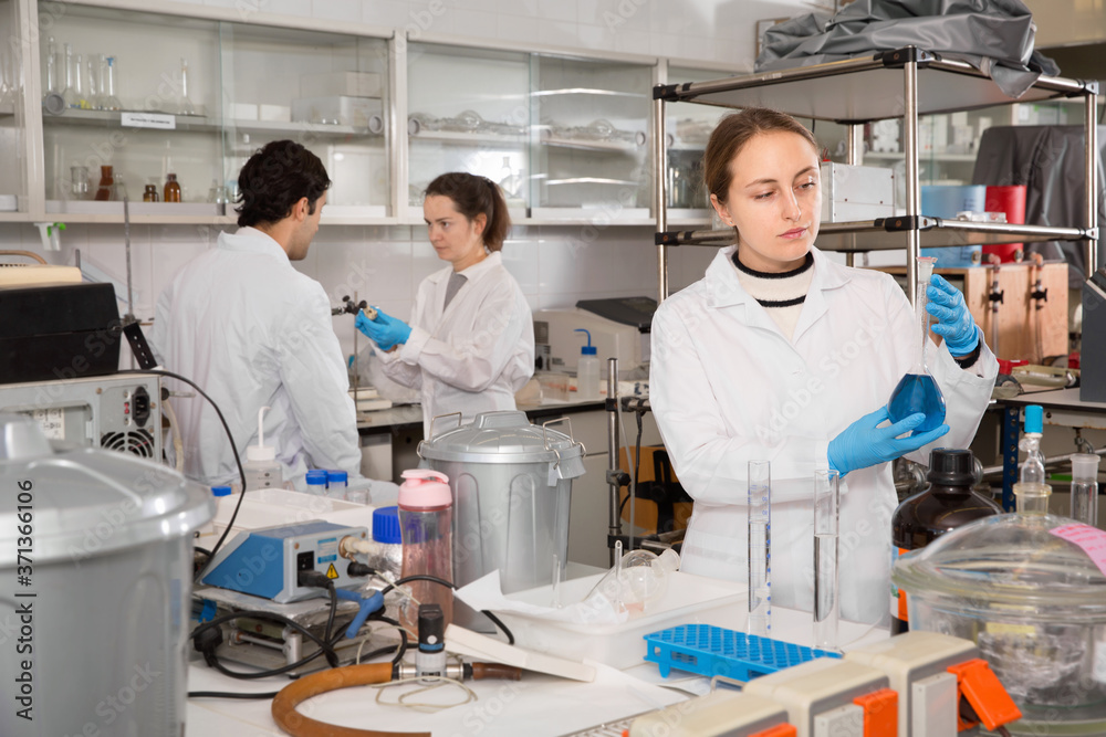 Young diligent efficient positive female lab technician working with ...