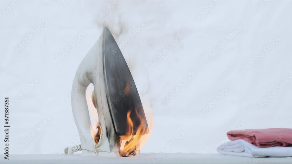 iron burns with open flame on ironing board close-up. Concept of fire ...