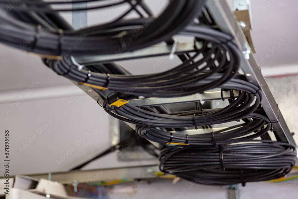 Cable management. Working wires, black cables wound into a coil, a ...