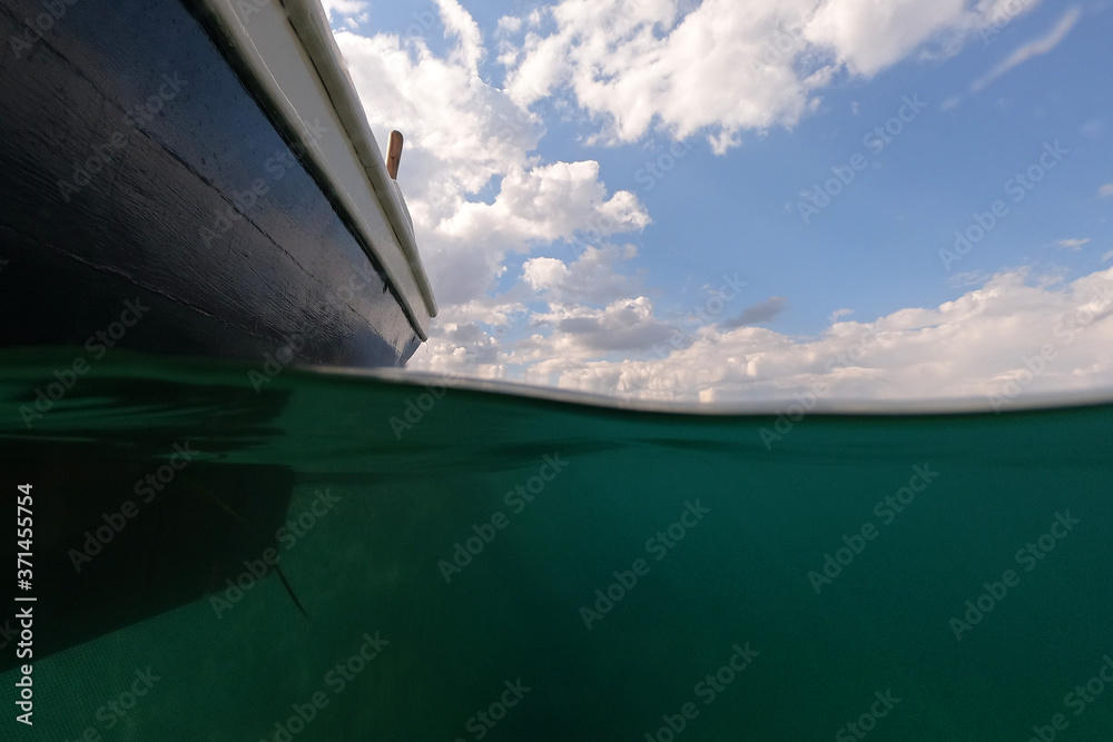 Underwater split photo of traditional classic wooden fishing boat ...