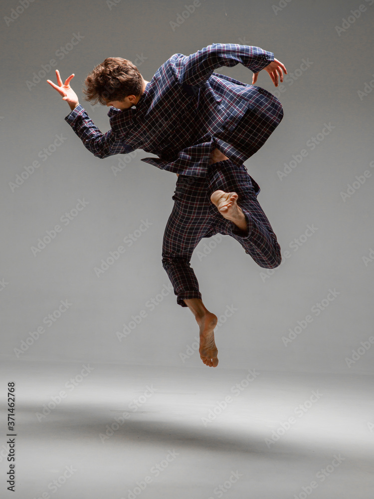 Stylish guy dancer levitating isolated on gray background. Dance school ...