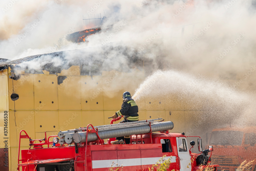 Fire extinguishing. Fire engine. A firefighter directs a stream of ...