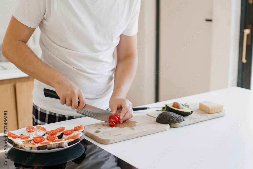Home cooking concept. Person cutting tomato slice for sandwich on ...