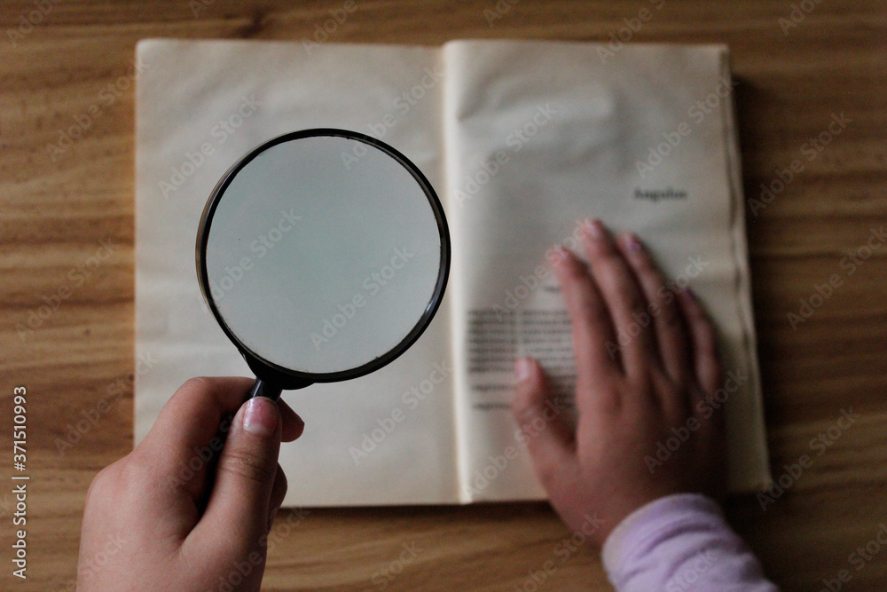 INVESTIGACIÓN CON LUPA Y LIBRO ANTIGUO Stock Photo | Adobe Stock