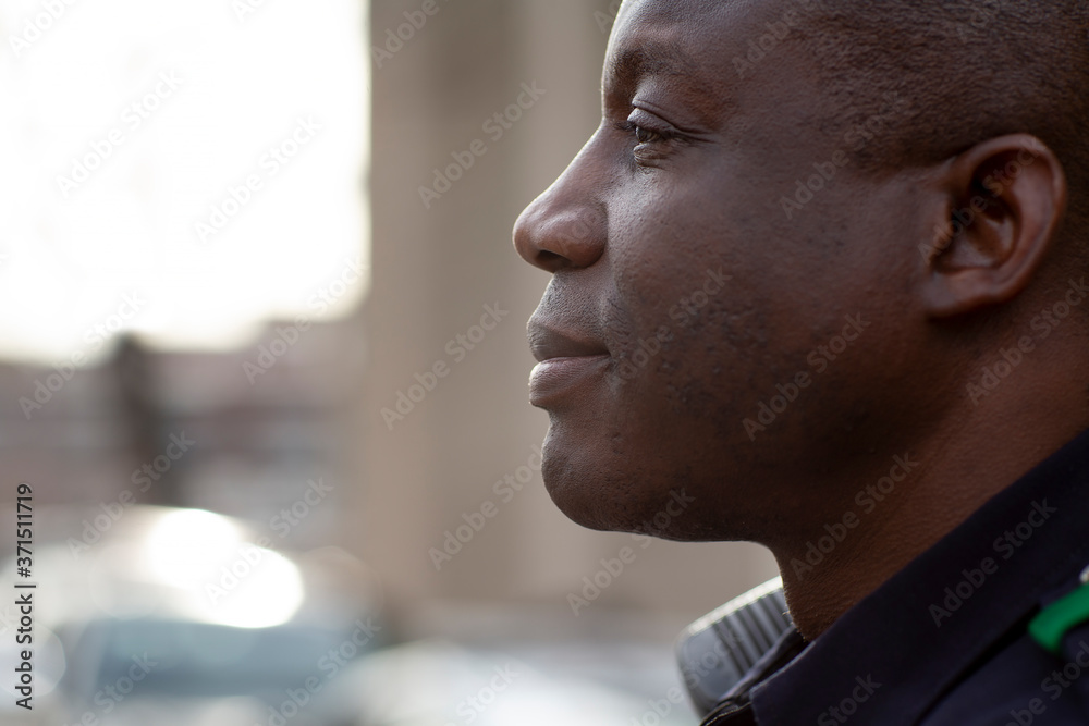 Close up profile Portrait of uniformed Police officer sitting outside ...