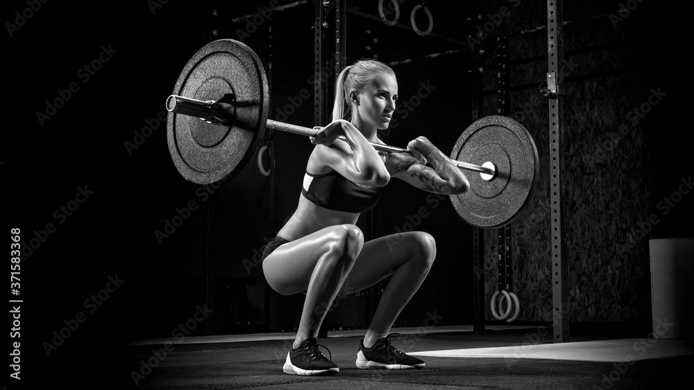 Indoors Shot Of Muscular Young Woman Doing Squats With Barbell In A Gym