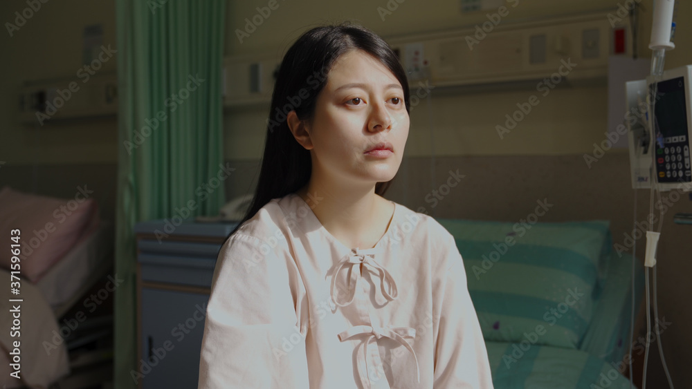 camera movement taiwanese female beside hospital window is gazing into ...