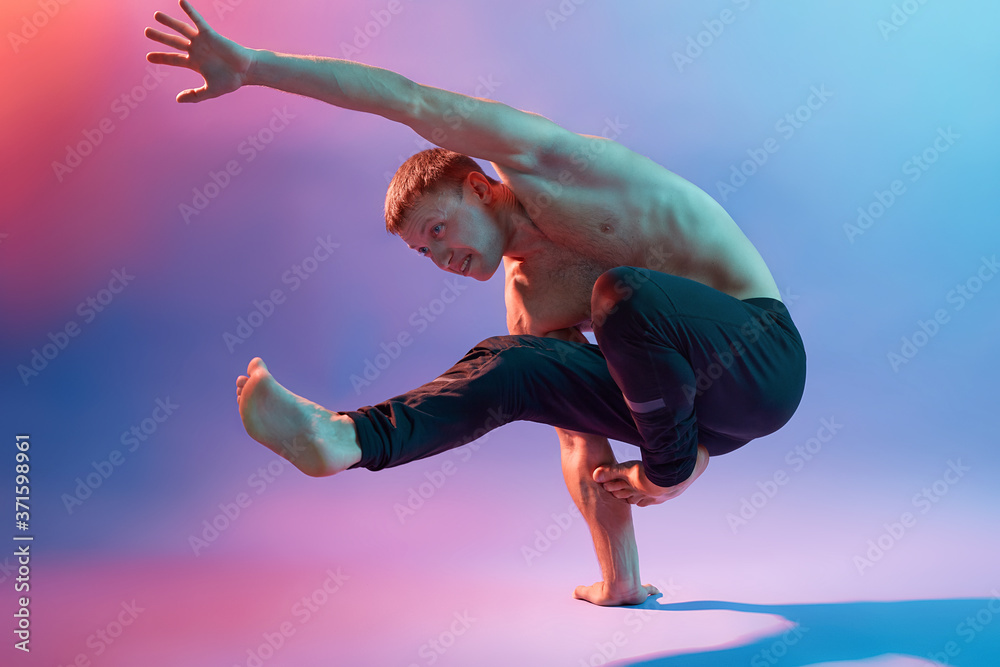 Acrobat showing his achievements, standing on one hand, demonstrating ...