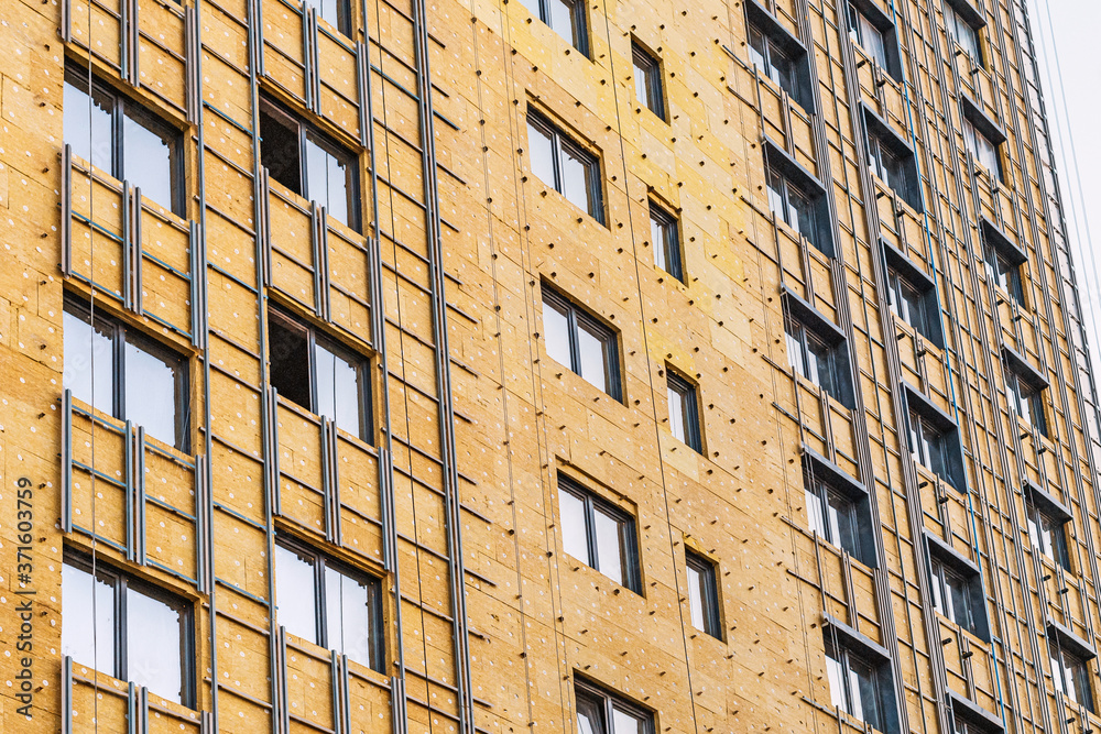 Installation of insulation on the exterior facade of a multi-storey ...