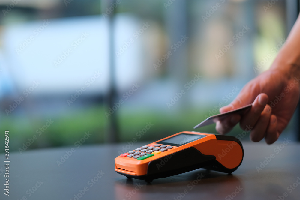 close up people holding credit card to pay over pos terminal on counter ...