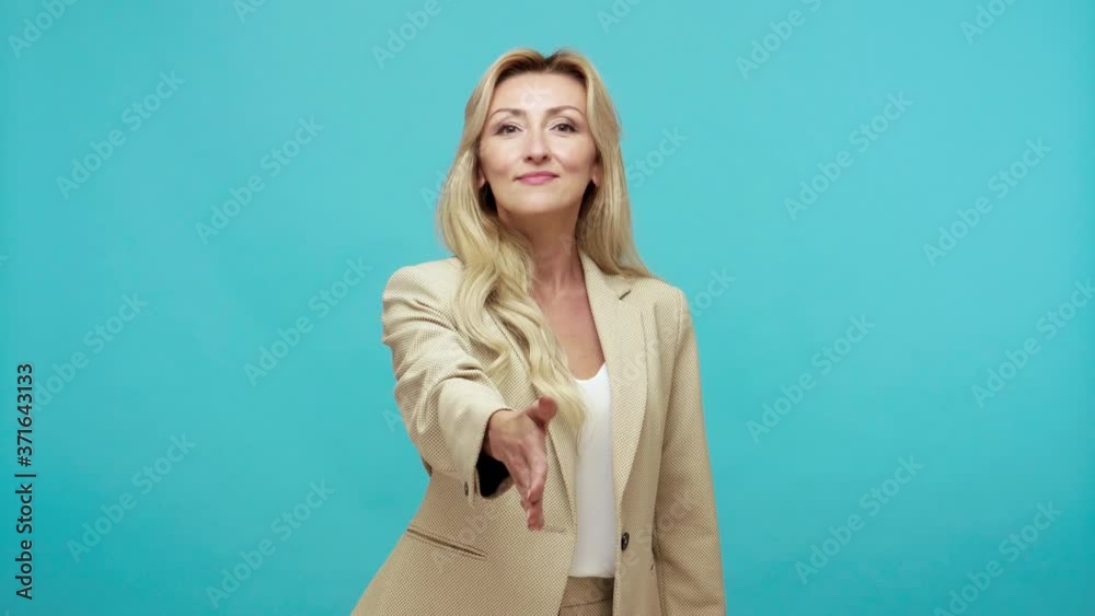 Serious beautiful middle aged woman in business suit holding out hand ...