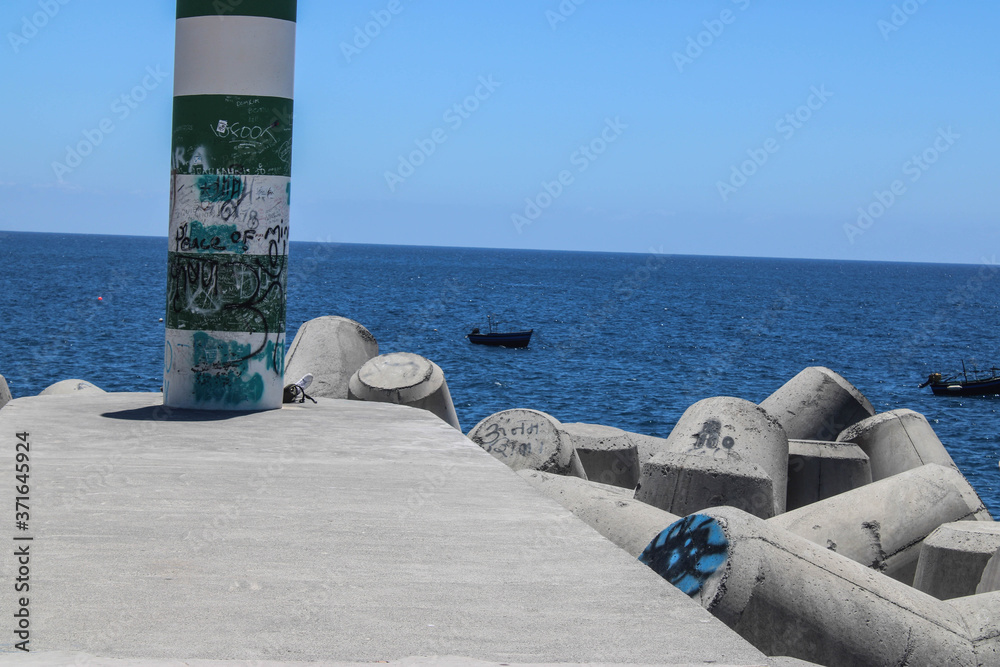 Grandes rocas rompeolas en las costas del mar con un cielo azul Stock ...