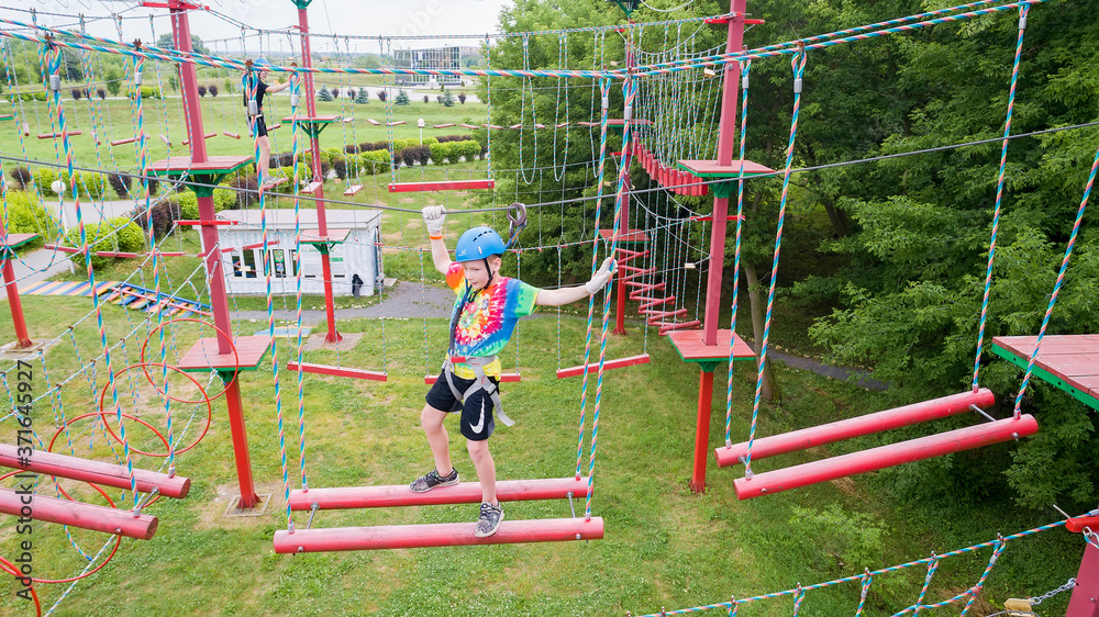 Rope park - climbing center. Hiking in the rope park girl in safety ...