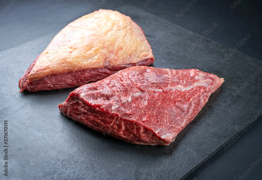 Raw dry aged wagyu cap of rump beef offered as close-up on black ...