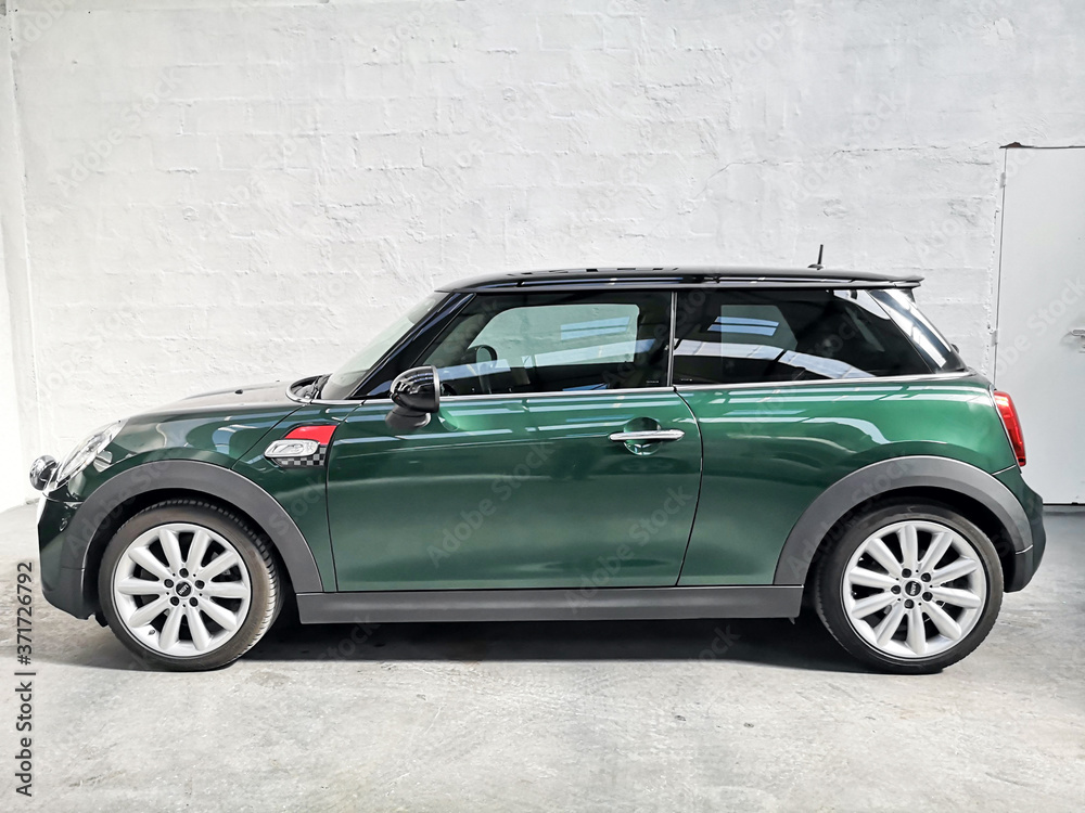 mini new car in racing green color on side view in dealership interior ...