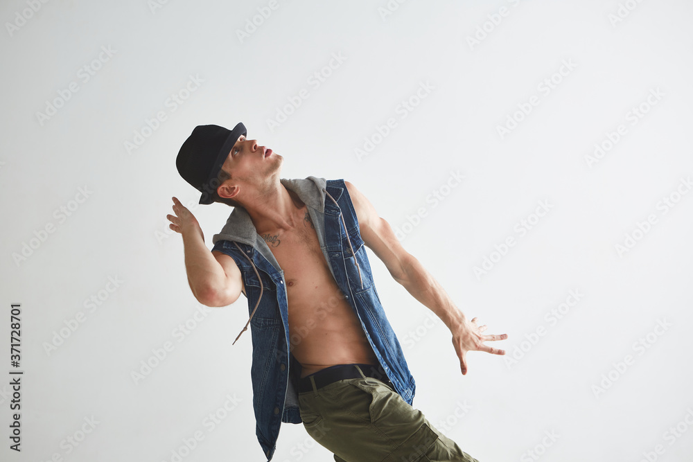 Stylish young guy dancer in hat dancing hip-hop in studio isolated on ...