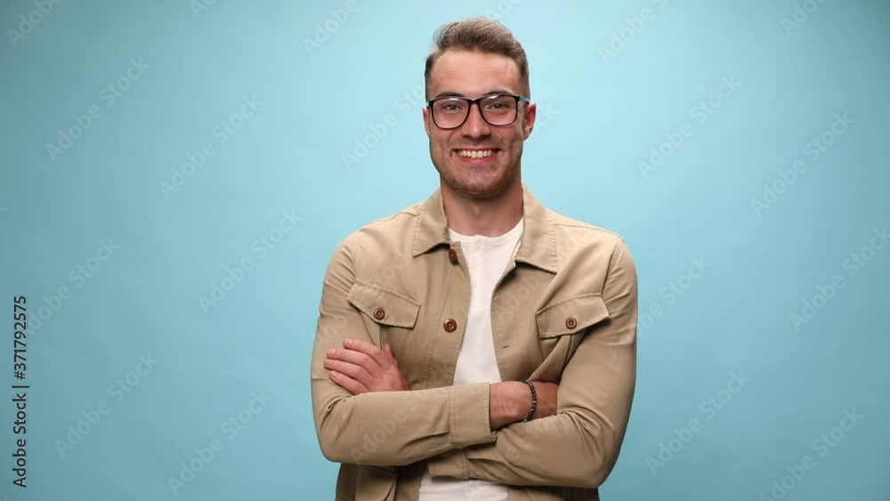 handsome casual man standing with his arms crossed, looking down ...