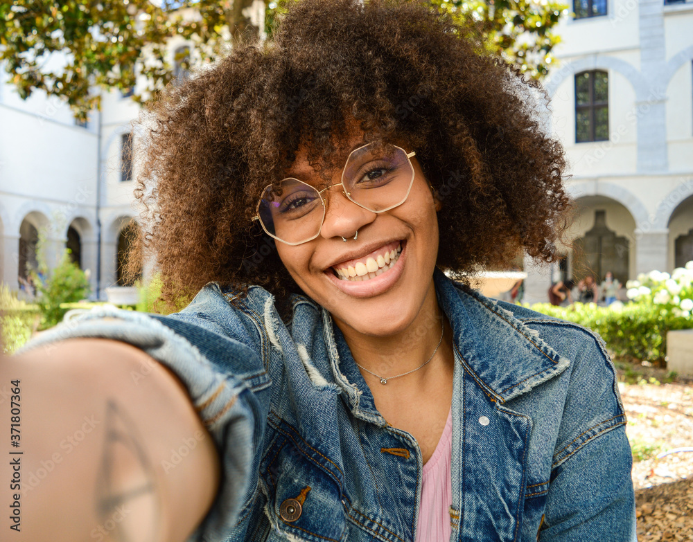 Beautiful young black Afro woman taking selfie with smartphone in the ...