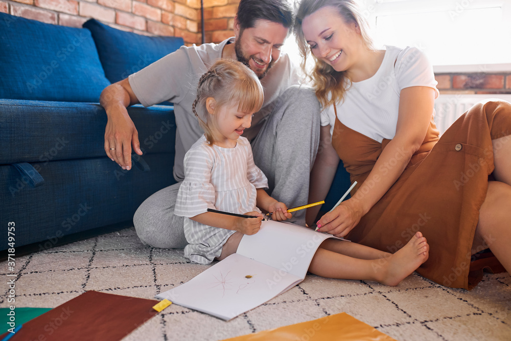 relaxed happy parents sit with daughter on the floor, caucasian little ...