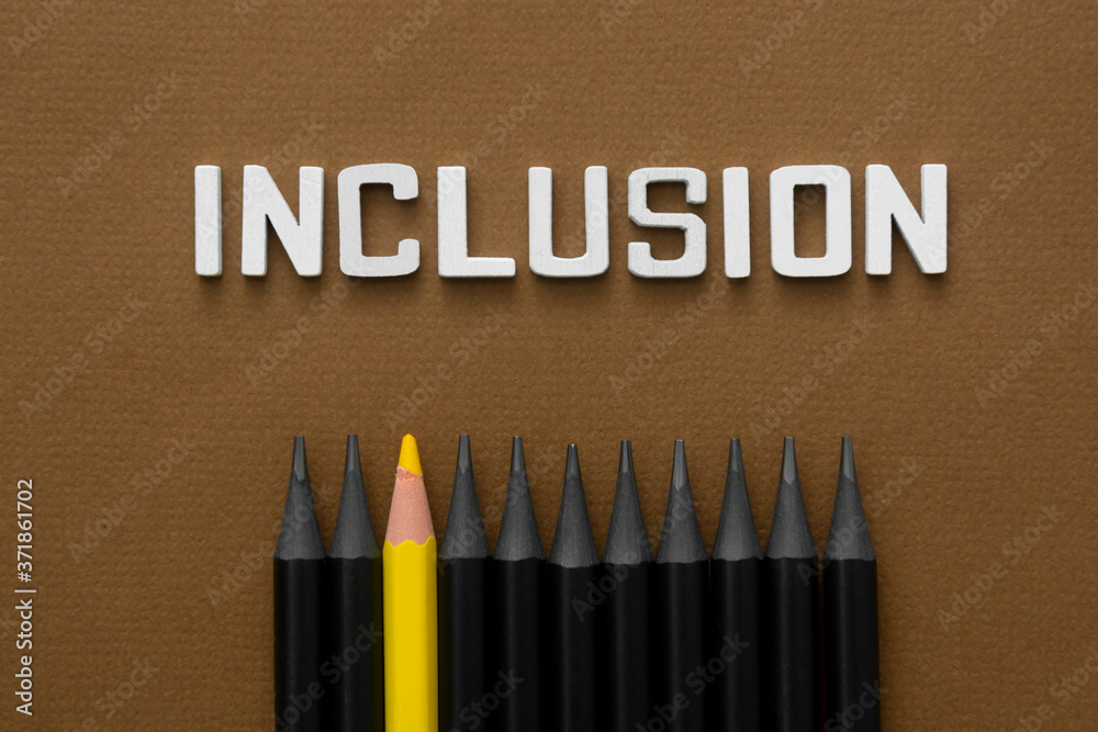Inclusion word with black pencils and one yellow pencil over brown ...