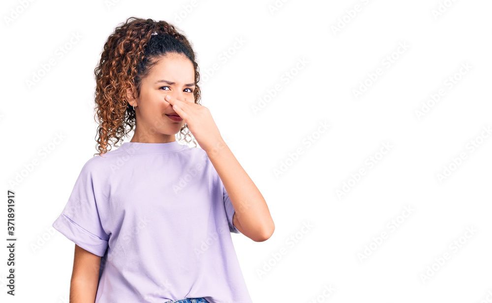 Beautiful kid girl with curly hair wearing casual clothes smelling ...