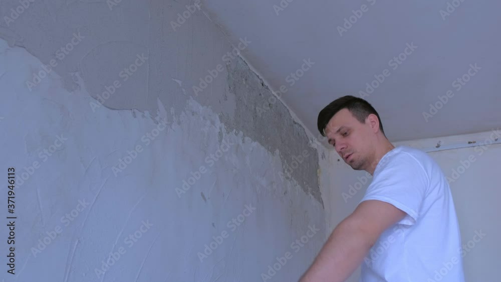 Plasterer man explains how to spackling wall with putty plaster ...