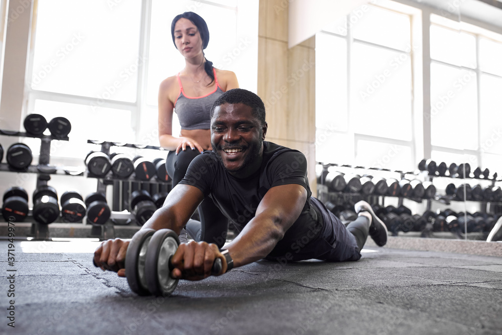 caucasian female trainer examine man while training in gym, it is ...