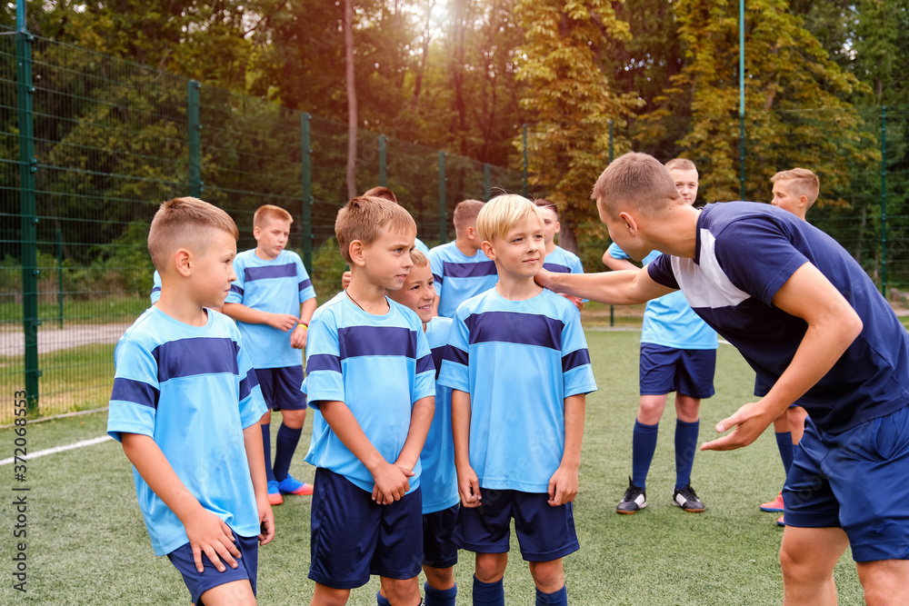 Kids in football uniform listening to explain of coach before match ...
