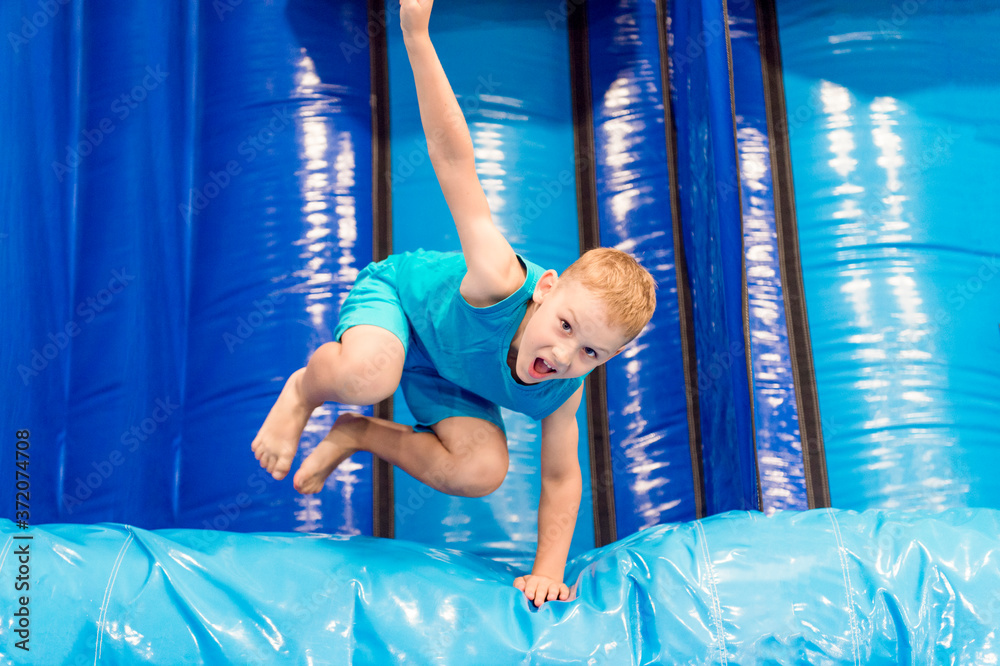 Child on blue playground trampoline. Kids jump in inflatable bounce ...