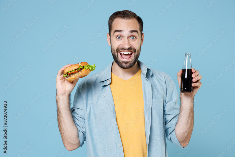 Excited young bearded man guy 20s wearing casual clothes posing holding ...