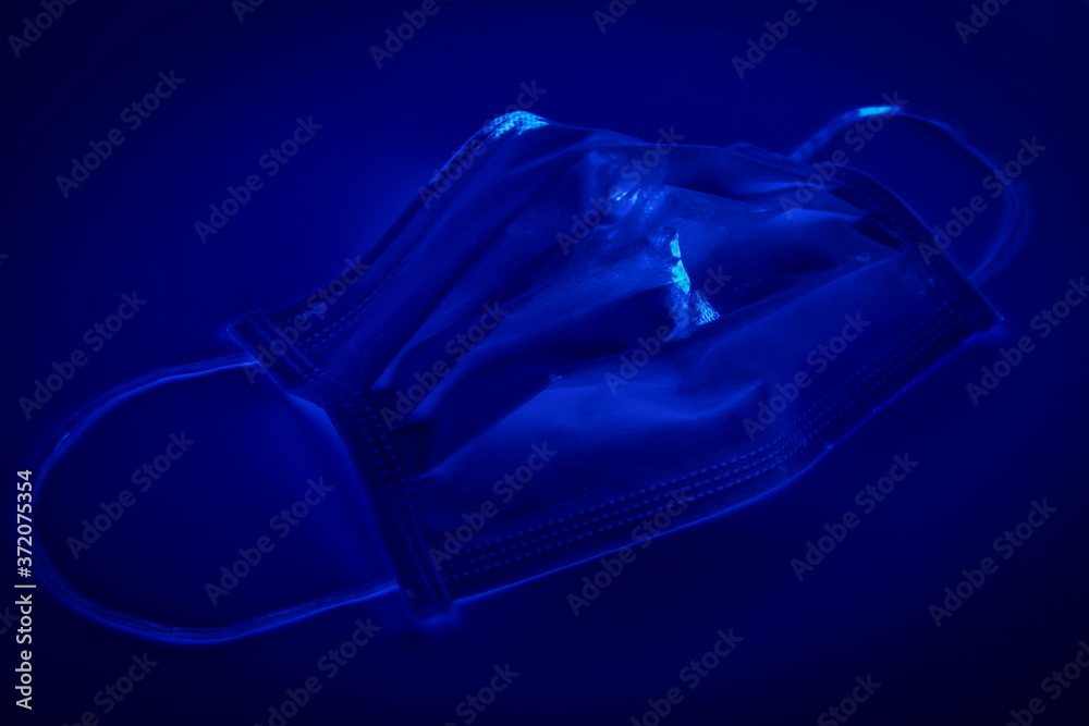 Medical mask under the black ultraviolet light to detect germ on the ...