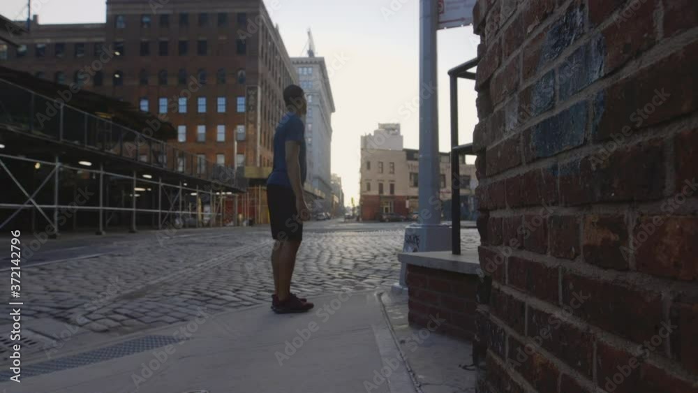 Vidéo Stock A runner stretching his leg on a lamp post in Dumbo, New ...