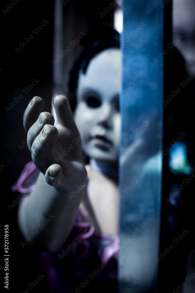 Stockfoto A very creepy doll reaching her hand inside the sliding door ...