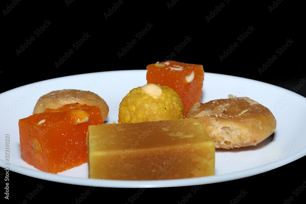 Indian sweets served in white plate. Halwa, badusha, ghee mysore pak ...