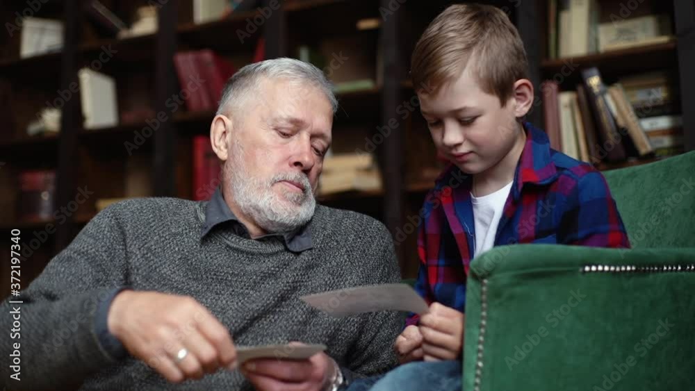 Close-up portrait of happy grandfather talking with little grandson ...