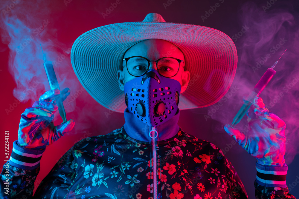 Strange man in medical respirator mask, glasses and hat holding two ...